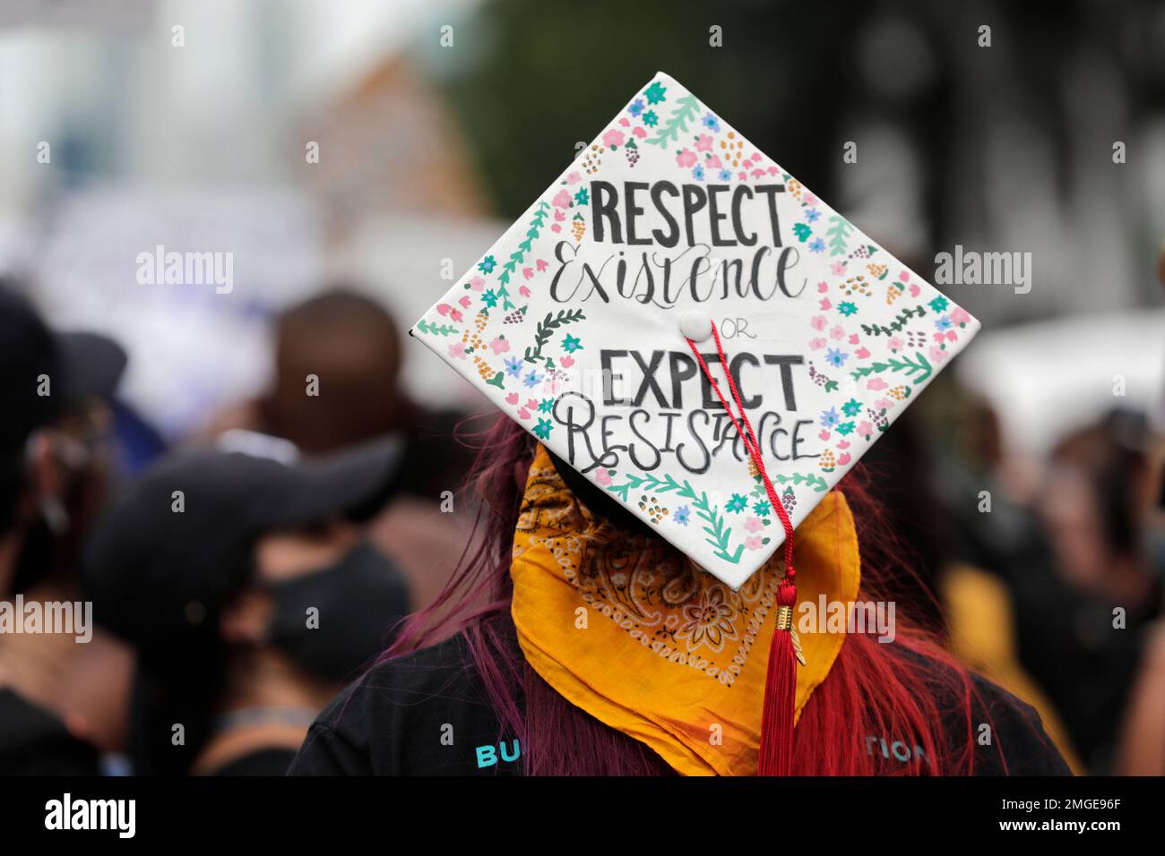 A woman wears a graduation cap during a protest over the death of ...