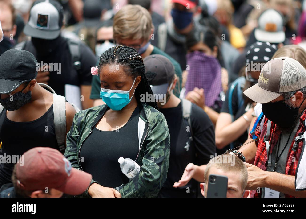 Demonstrators bow their heads as Denver Broncos linebacker Jeremiah ...