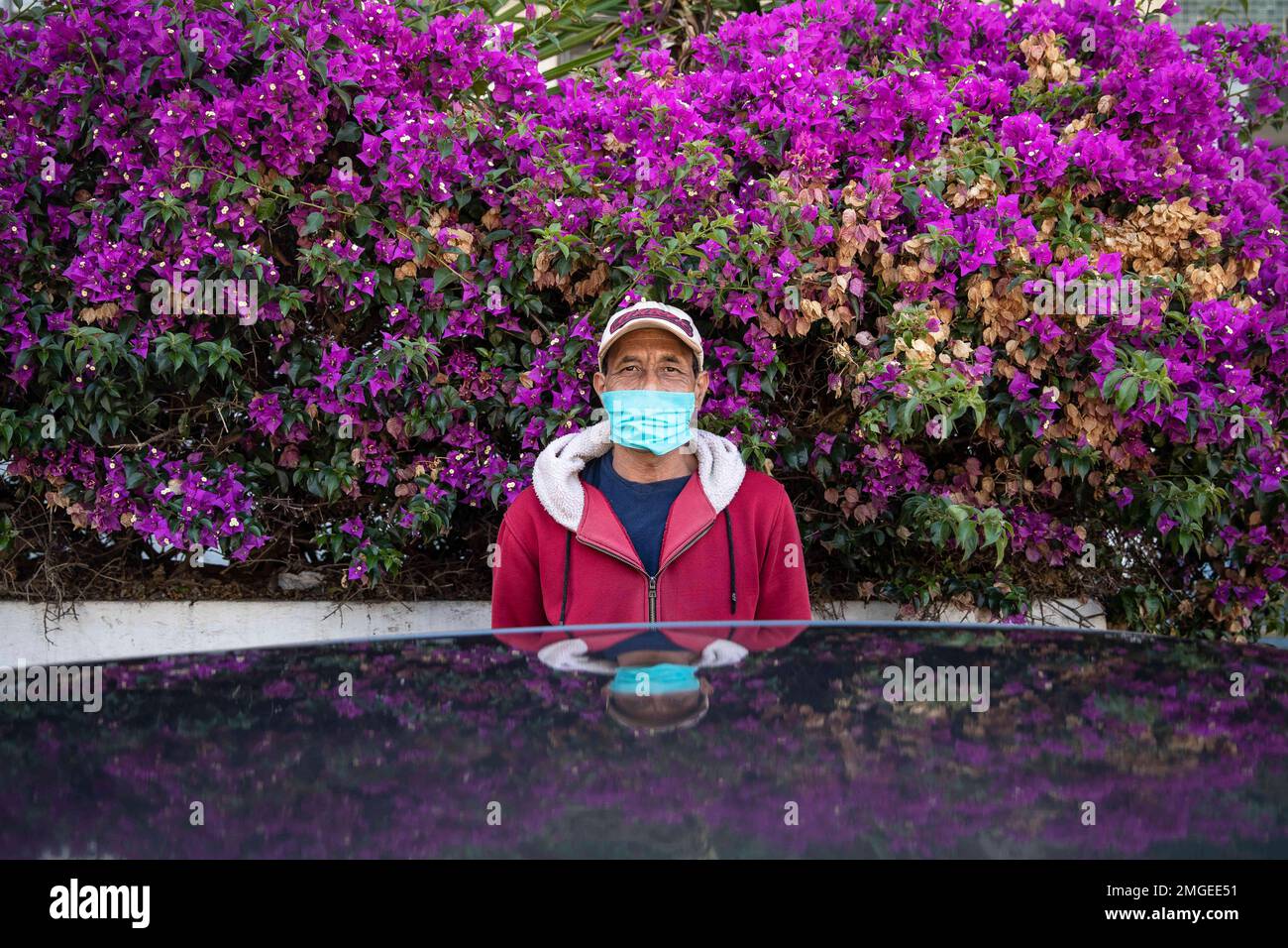 Ibrahim, a parking attendant, poses for a photo in his face mask during ...