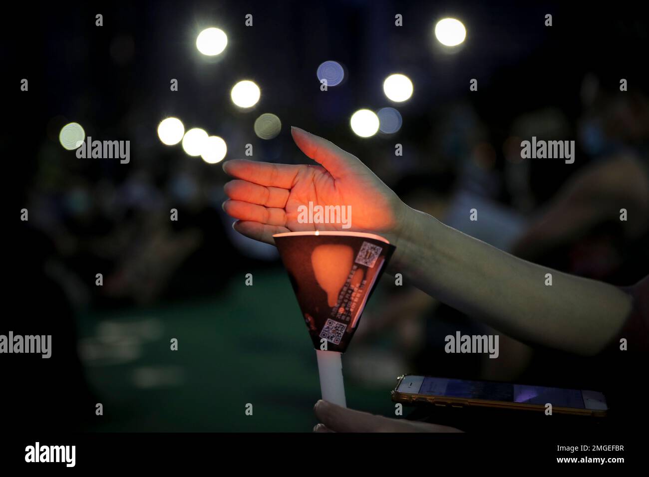 An activist holds a candle during a vigil for the victims of the 1989 ...
