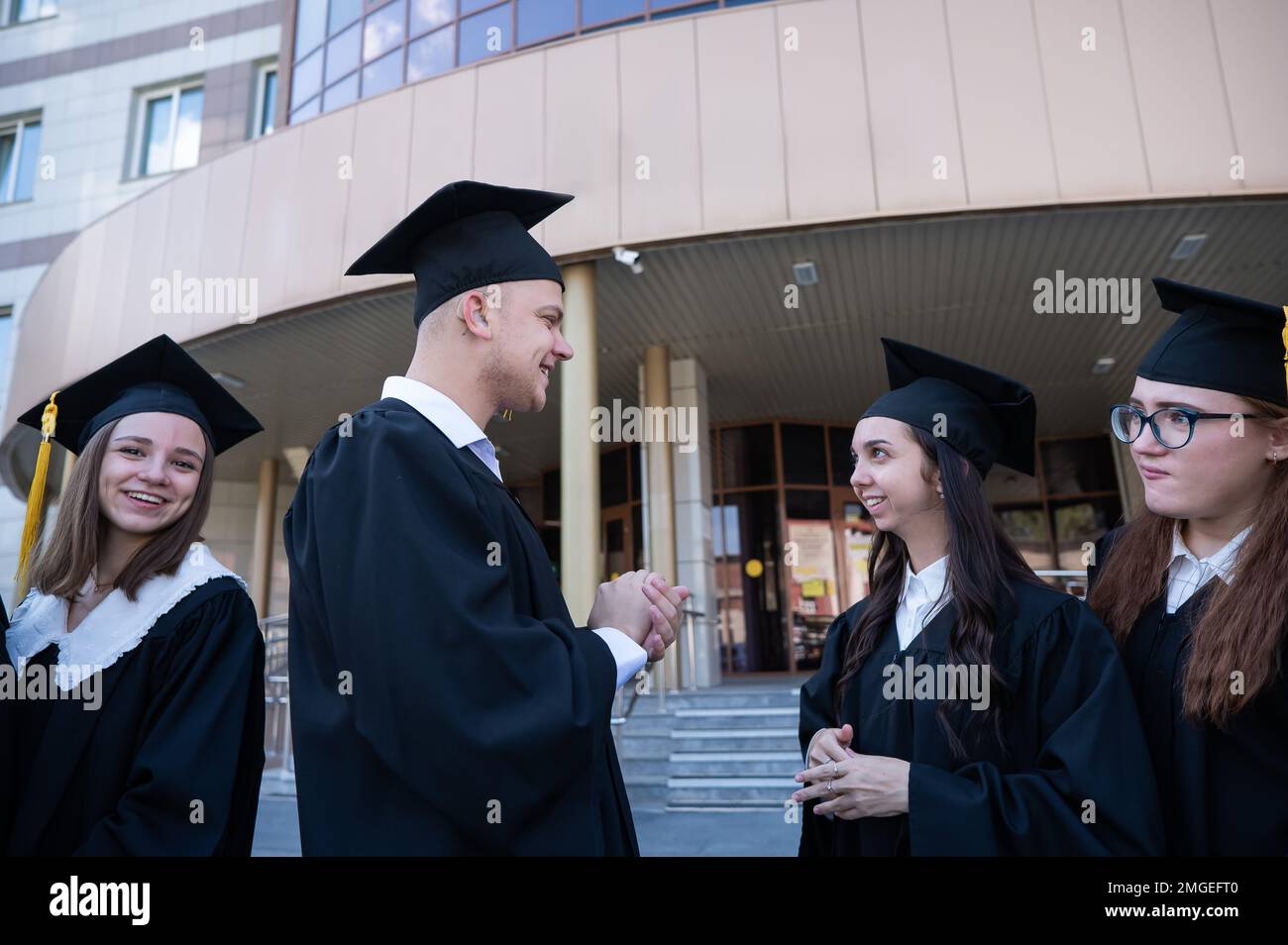 Happy students in graduate gown communicate in sign language Stock ...