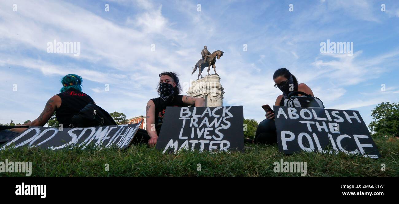 Protesters hold signs around the statue of Confederate Gen. Robert E ...
