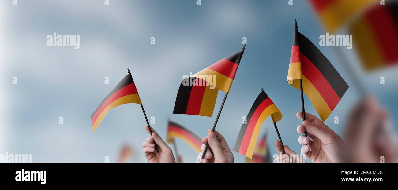 A group of people holding small flags of the Germany in their hands ...