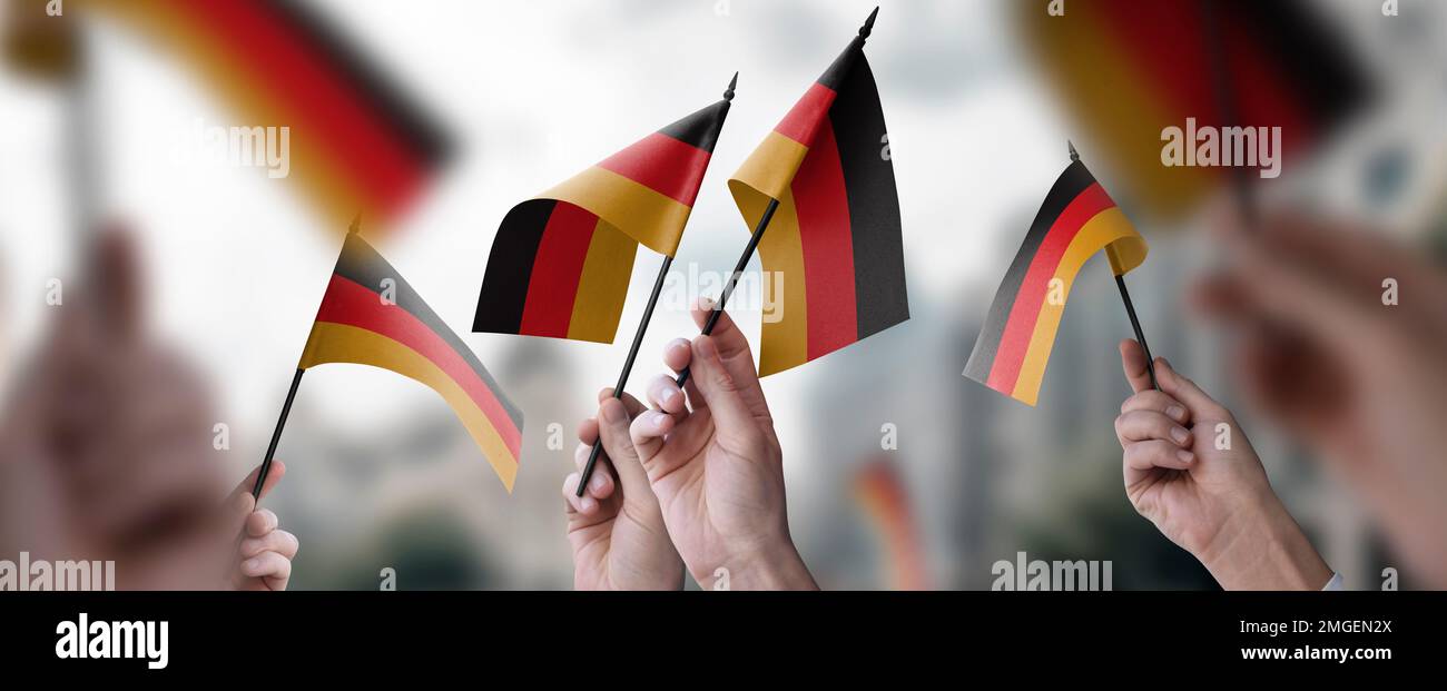 A group of people holding small flags of the Germany in their hands ...