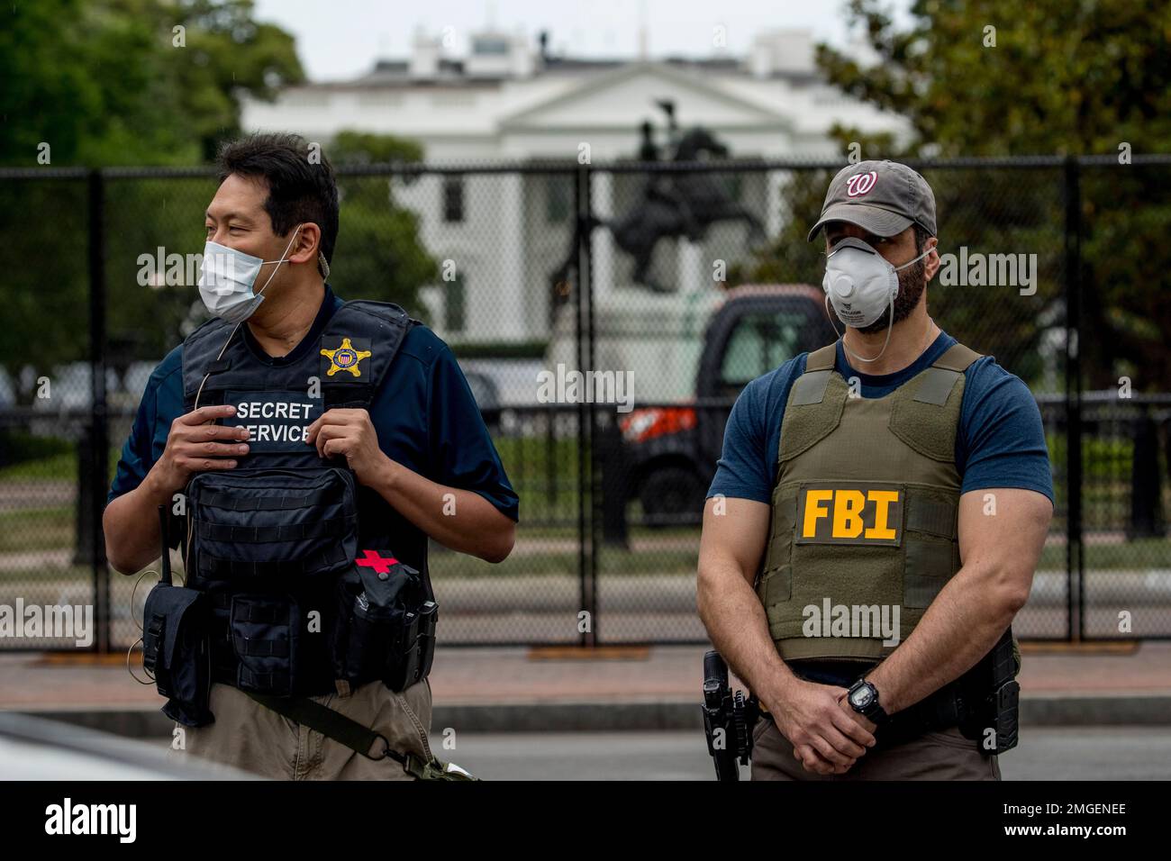 The White House is visible behind a large security fence as uniformed ...
