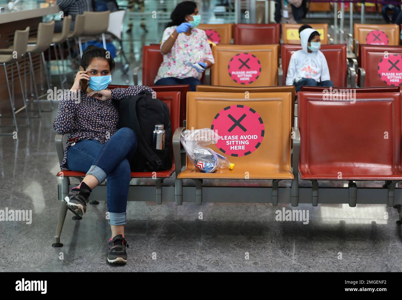 Passengers wearing face masks are seated maintaining social distancing ...