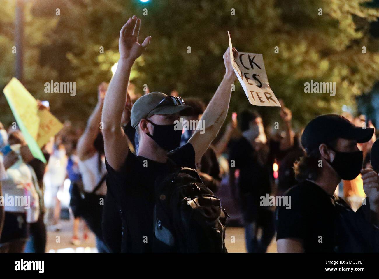 A protester raises his hands over the deaths of George Floyd and ...
