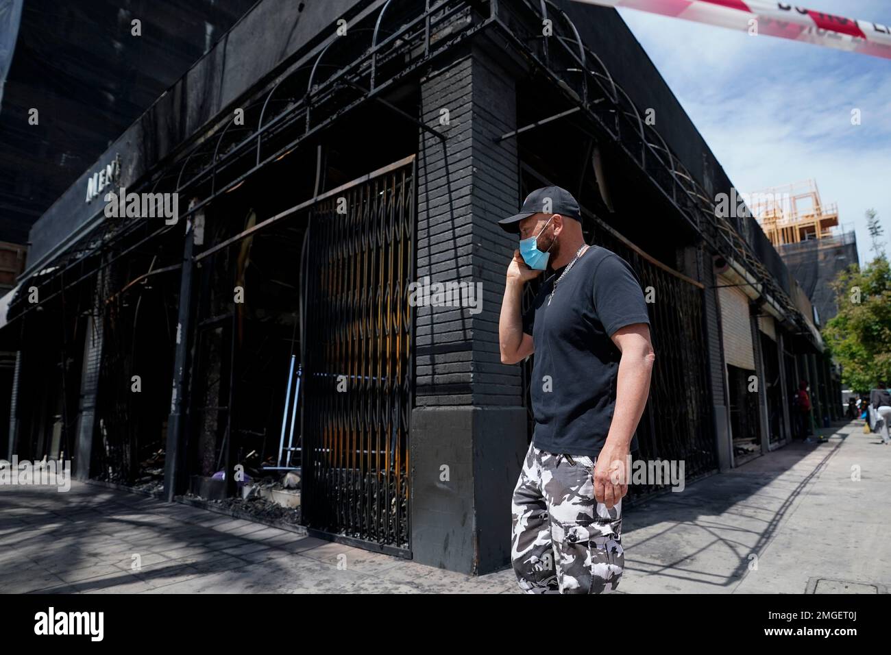 Vasken Samuelian, owner of Men's Suit Outlet, walks near the burned ...