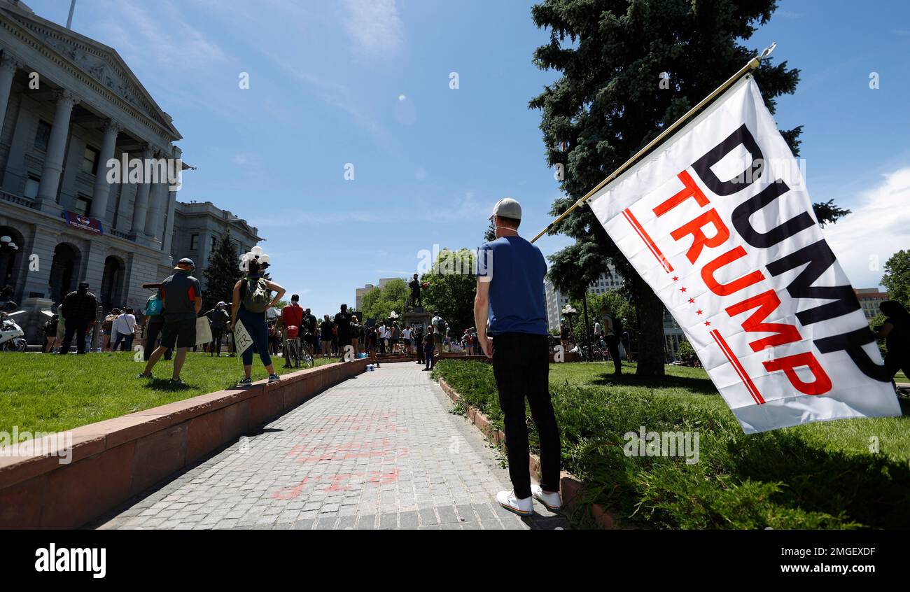 Fritz Sanders, of Denver, waves a flag during a protest outside the ...