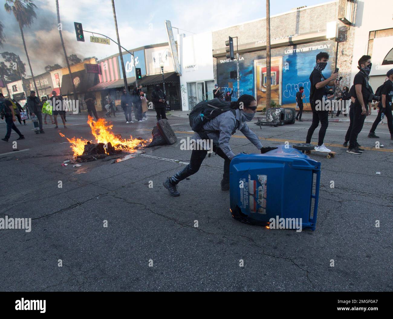 A protester pushes a trash can police officers during a protest over ...