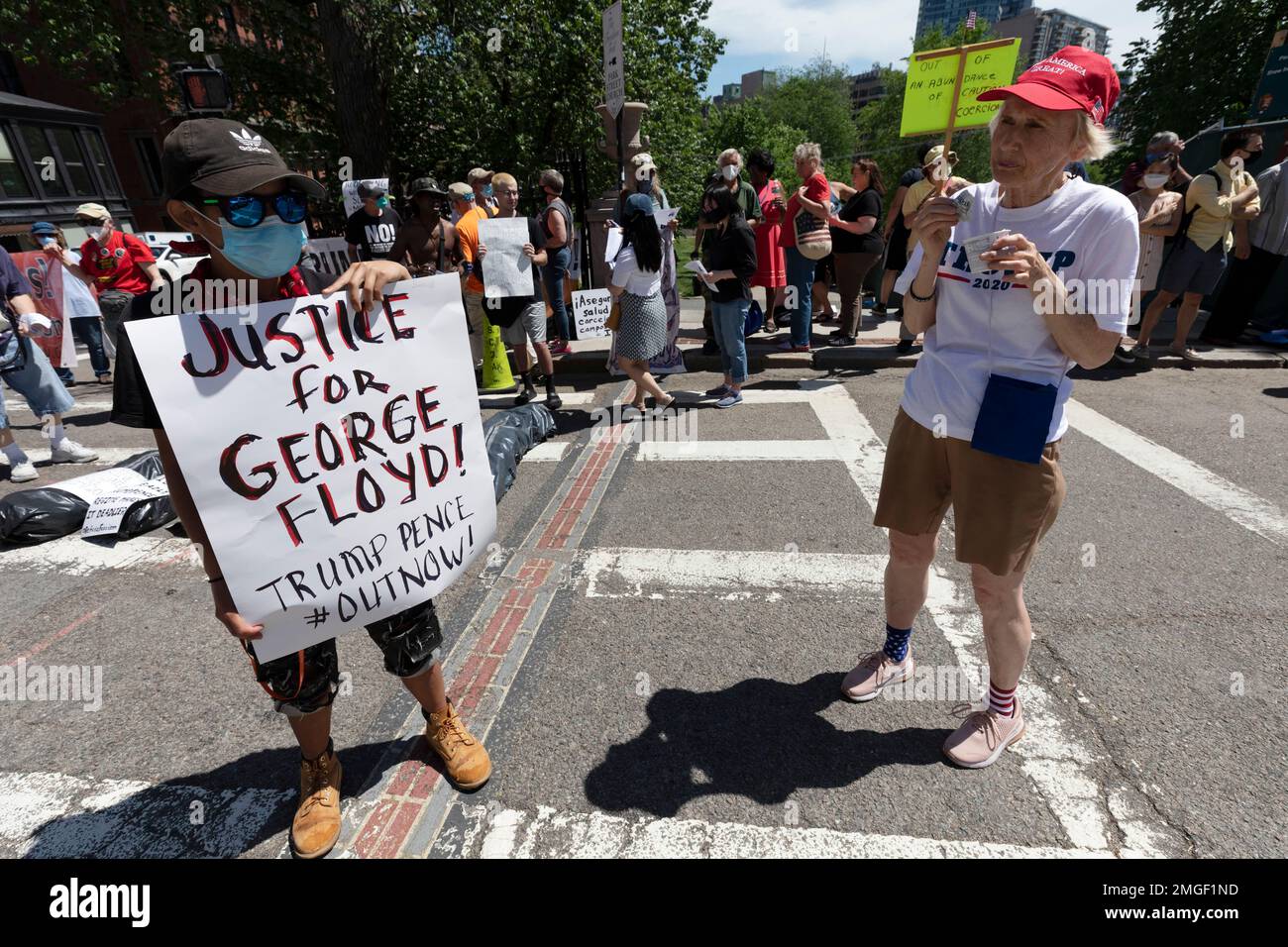 A Trump supporter stands next to a woman protesting against the death ...
