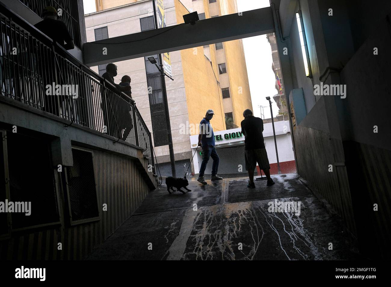 A man and his dog take shelter from the rain in Caracas, Venezuela ...