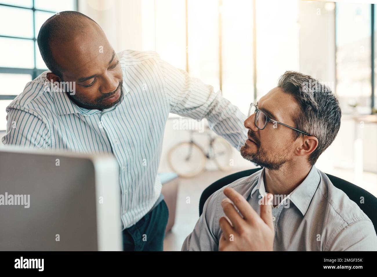 Teamwork is essential in any successful company. two businessmen using ...