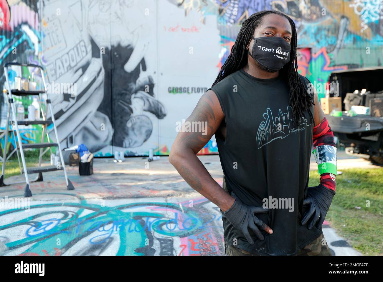 Artist Theo Ponchaveli poses in front of an unfinished mural of George ...