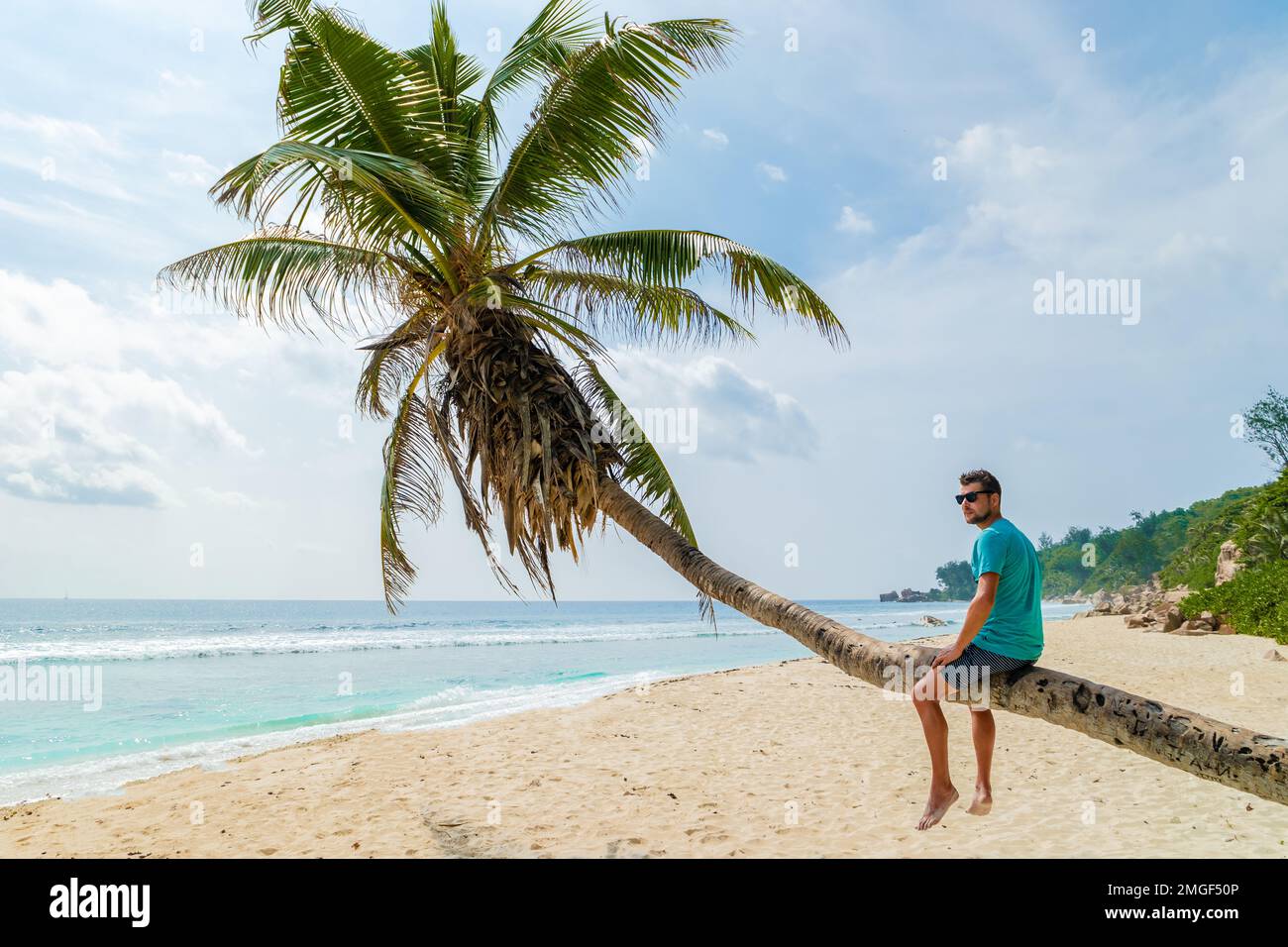 Young men relaxing at a palm tree on a tropical white beach at the La ...