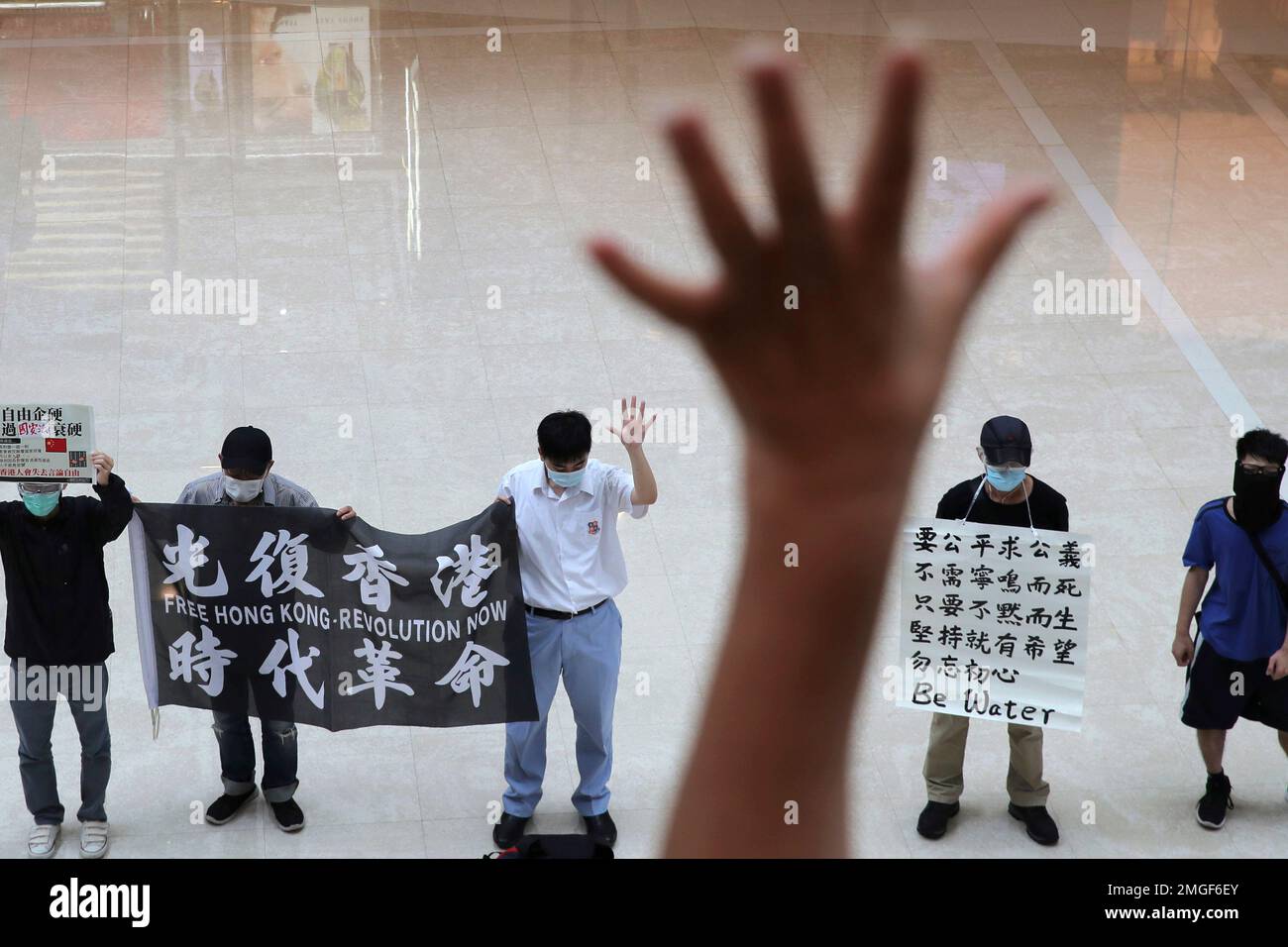 Protesters gesture with five fingers, signifying the "Five demands ...