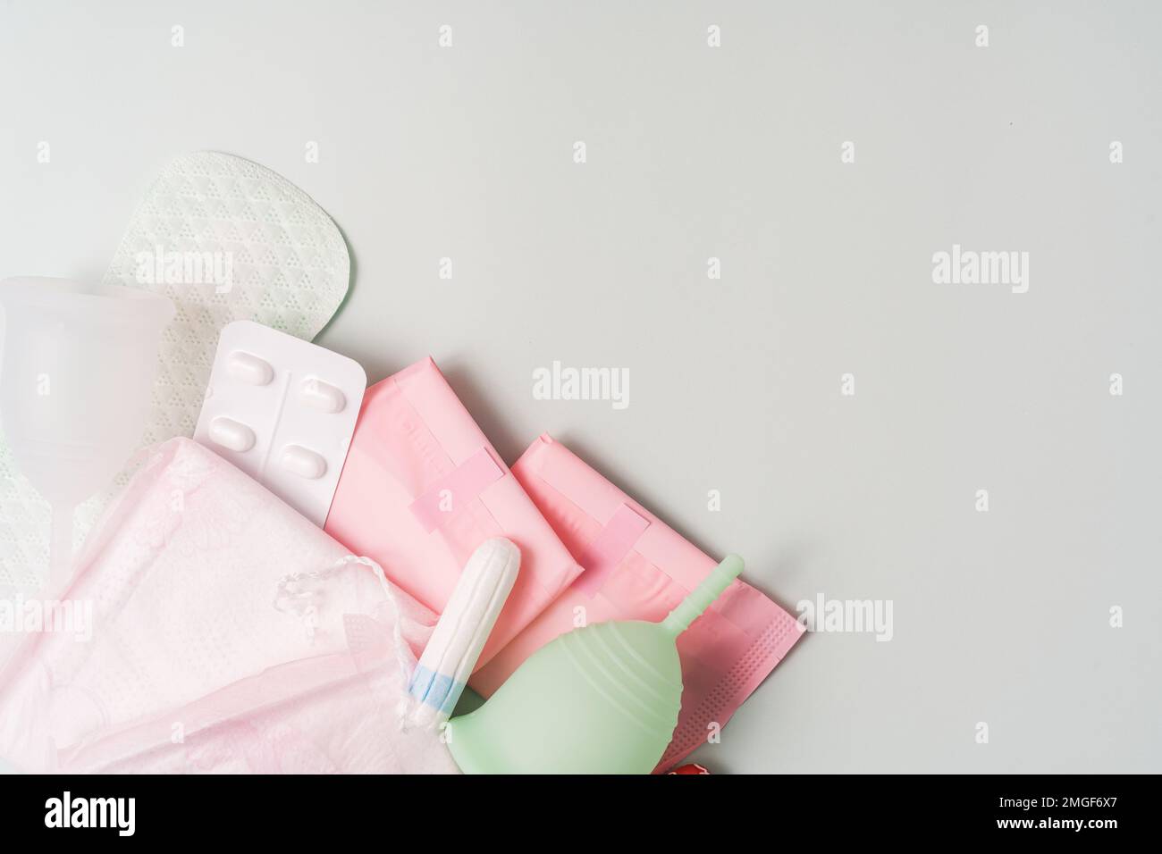 Supplies for the menstrual cycle on a green background Stock Photo - Alamy