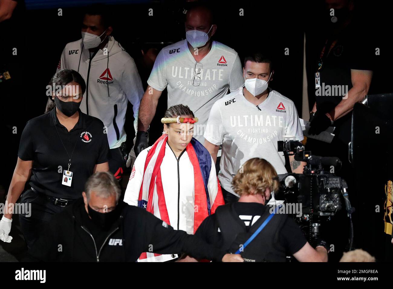 Michelle Waterson, center, enters the arena surrounded by her team ...