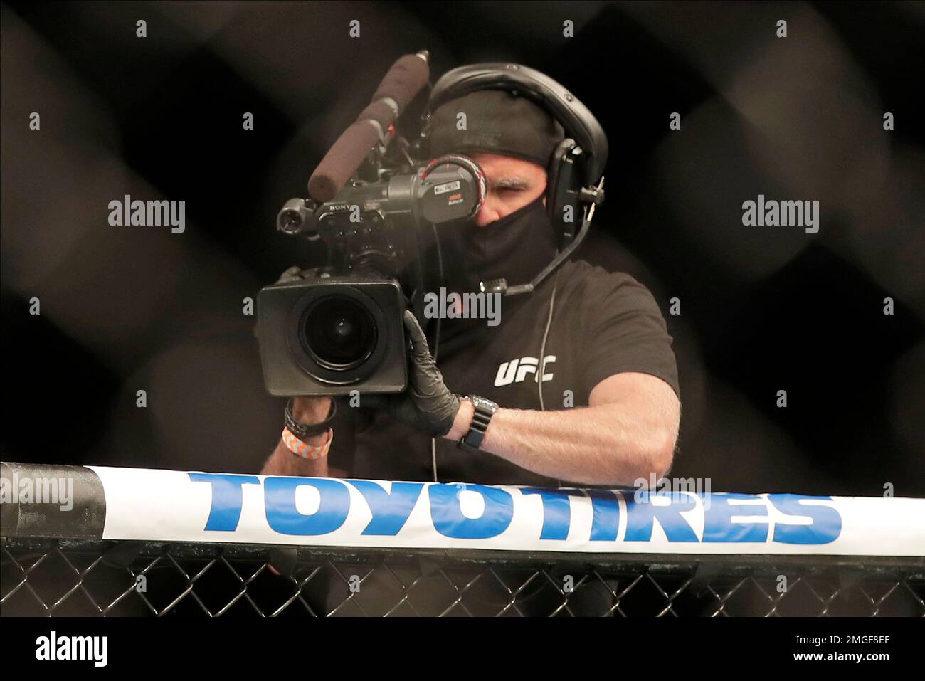 A TV camera man wearing a mask covers a UFC 249 mixed martial art bout ...
