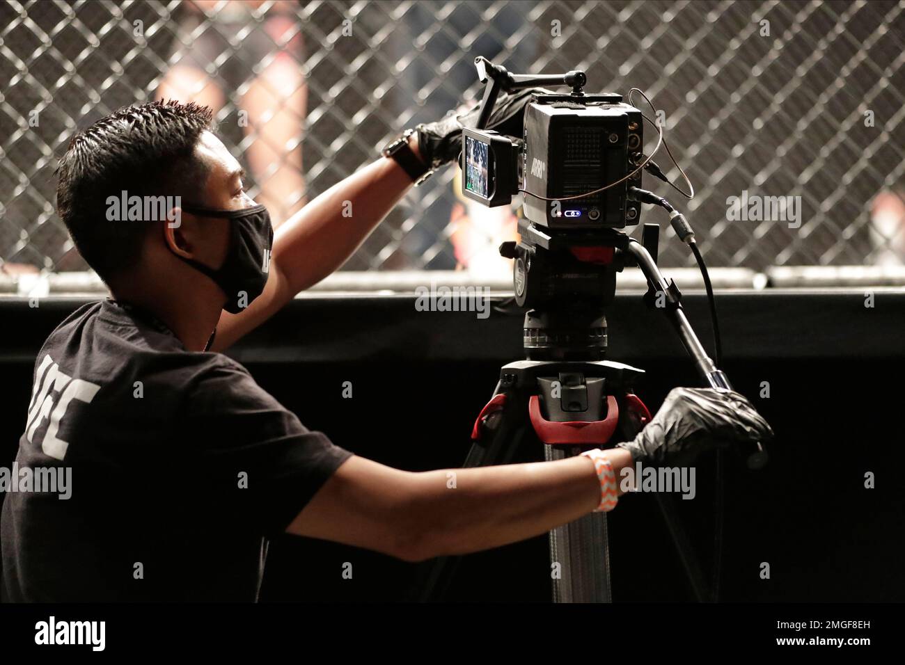 A camera man wearing a mask because of the coronavirus pandemic covers ...