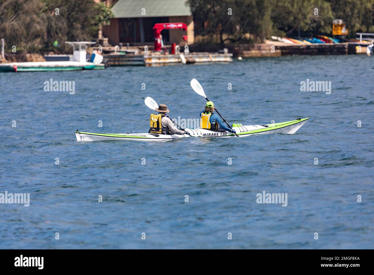 Two senior citizens paddle in their Mirage Kayak on Pittwater along the ...