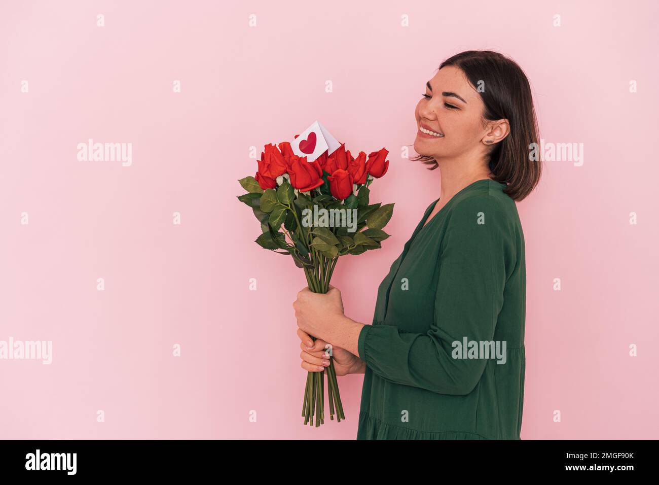 Lady with bouquet of red roses against pink background Stock Photo - Alamy