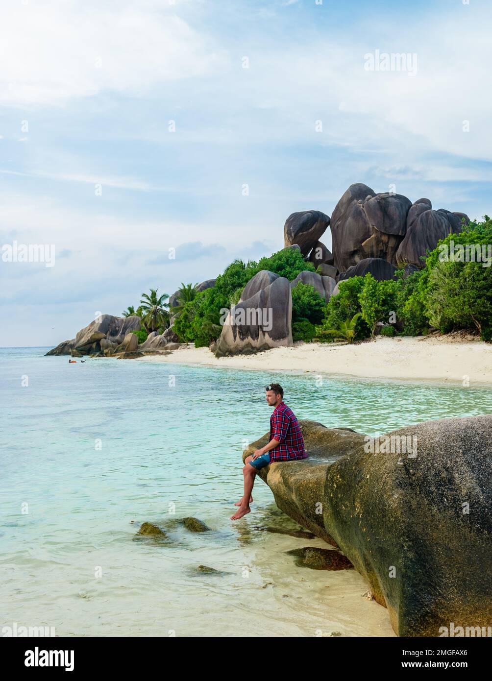 Young men at a white tropical beach Anse Source d'Argent beach La Digue ...