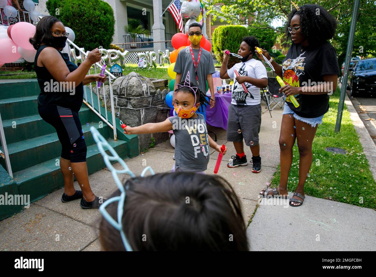 Family members including Zariah Turner, 4, center, use bubble wands ...