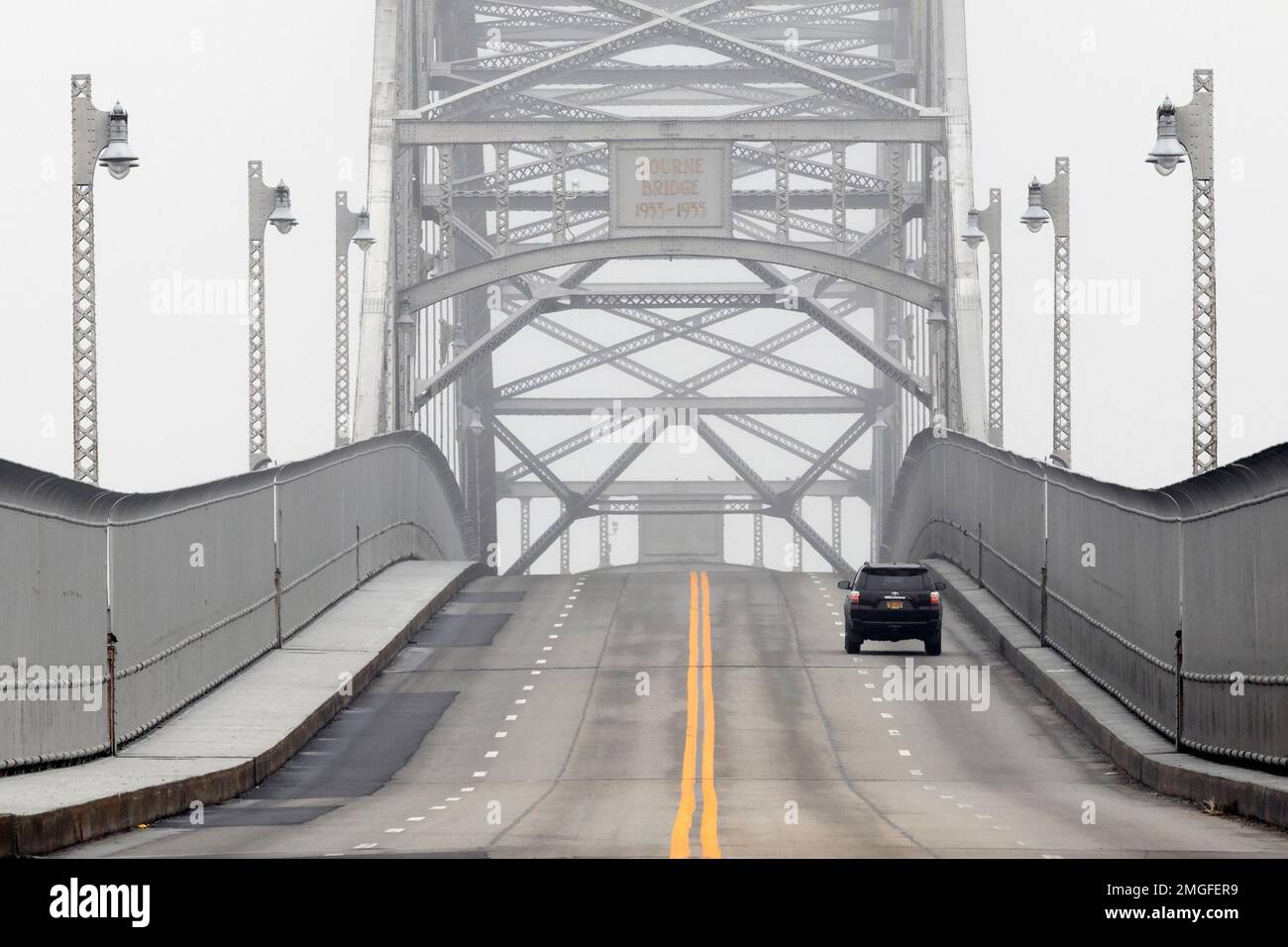 A lone vehicle leaves Cape Cod over the usually busy Bourne Bridge ...