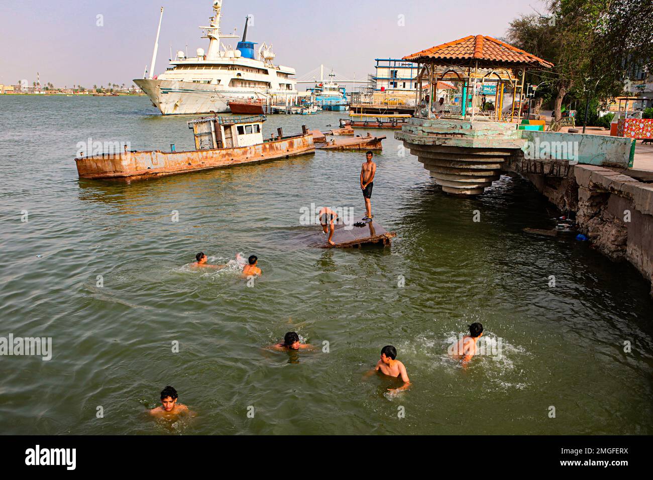People swim in the Shatt al-Arab waterway to beat the heat, during Eid ...