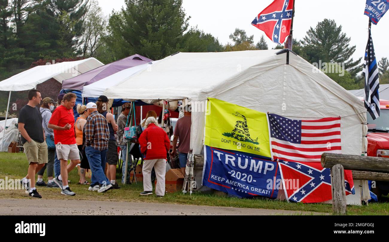 People gather around a vendor's tent at a flea market in Farmington, Pa ...