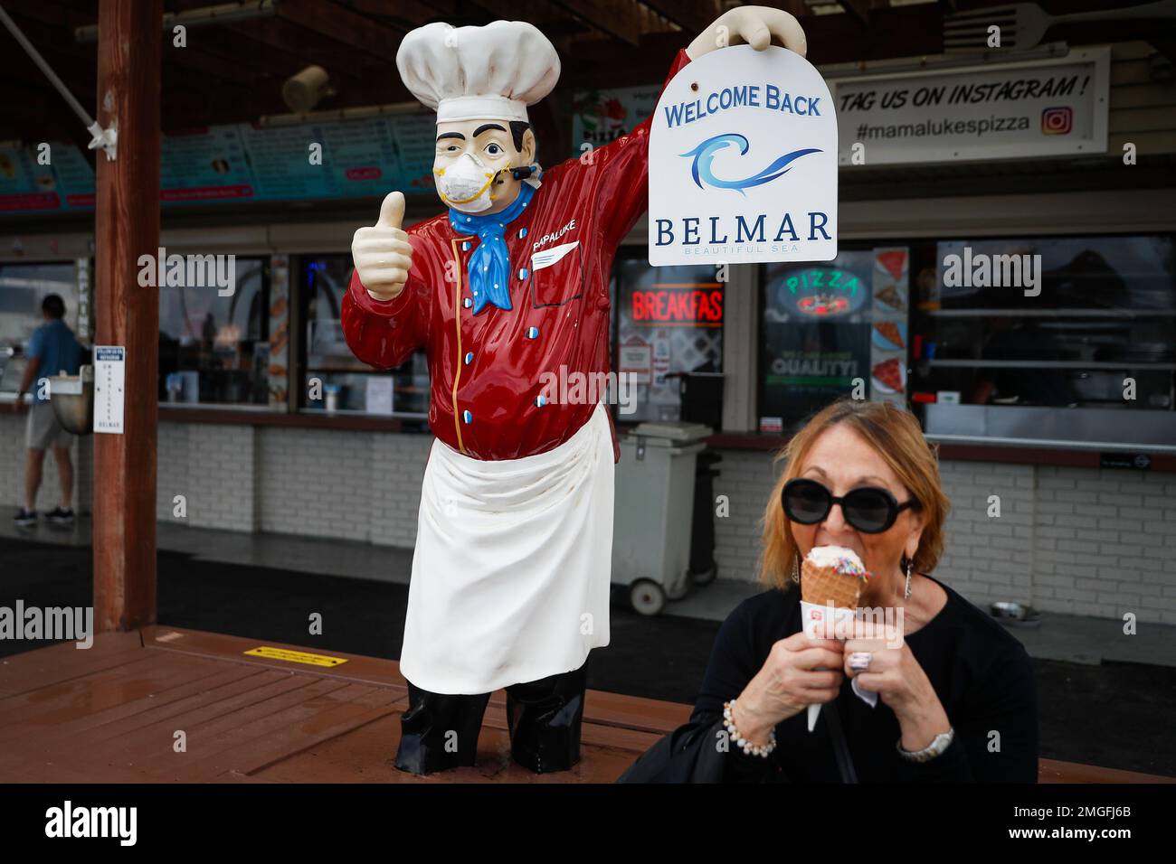 A protective mask adorns a statue outside Mamalukes Pizza & Ice Cream ...