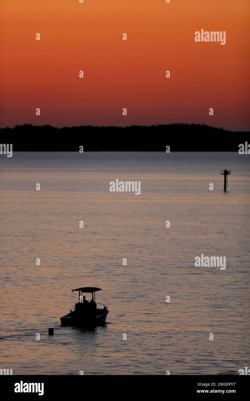 A small boat chugs along Honga River near the Chesapeake Bay as the sky ...