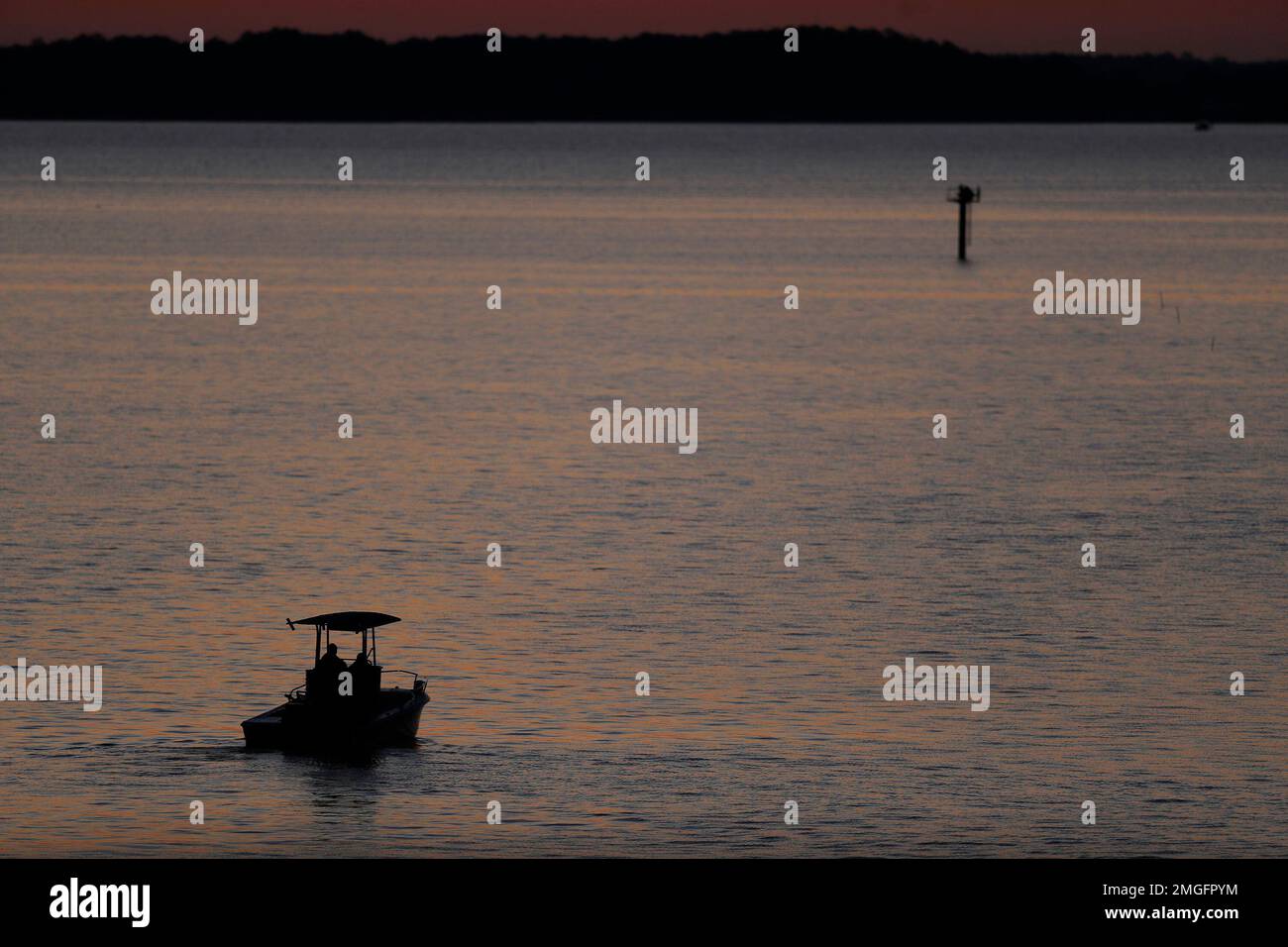 A small boat chugs along Honga River near the Chesapeake Bay as the sky ...