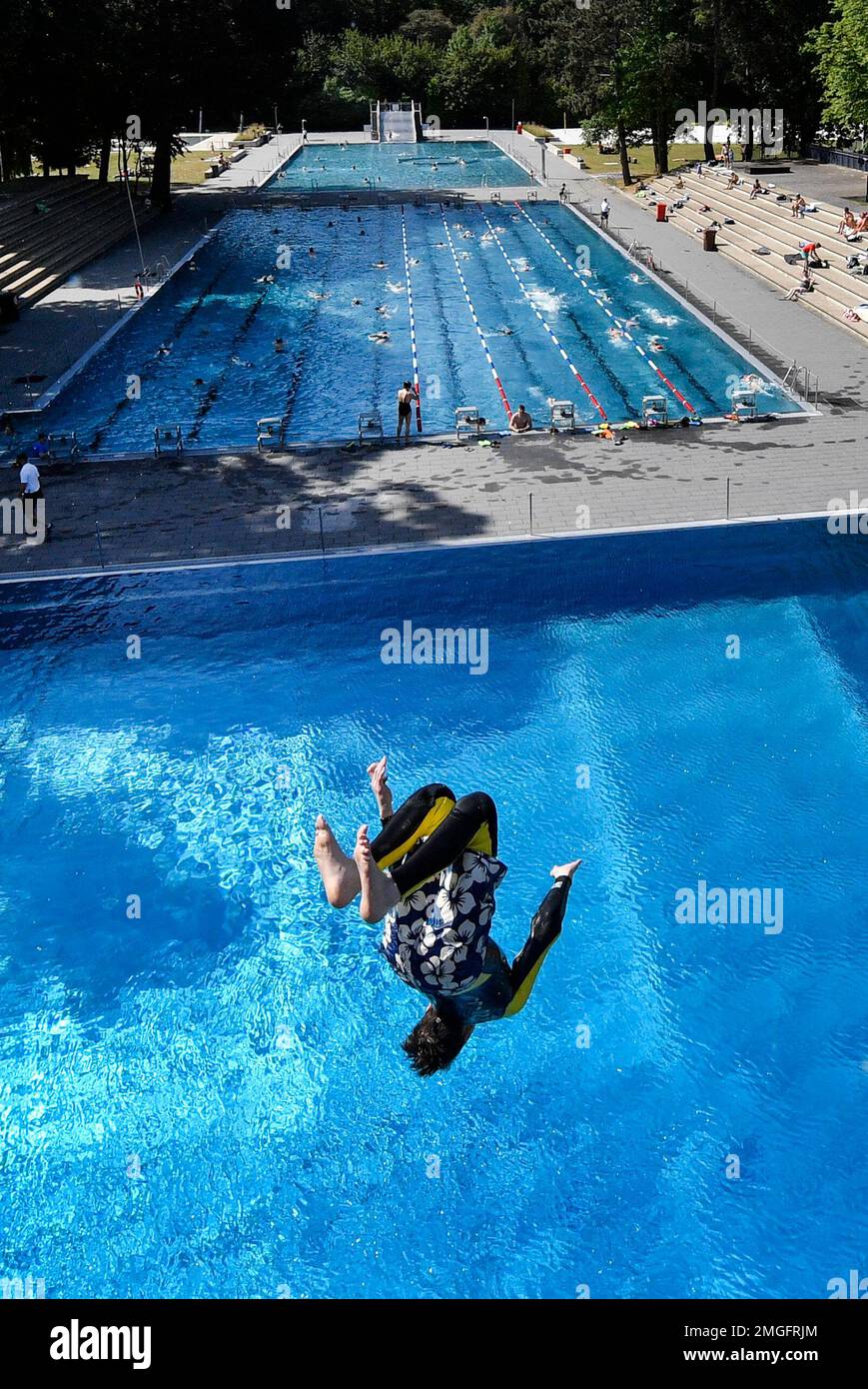 A swimmer jumps into the water during the opening day of the public ...