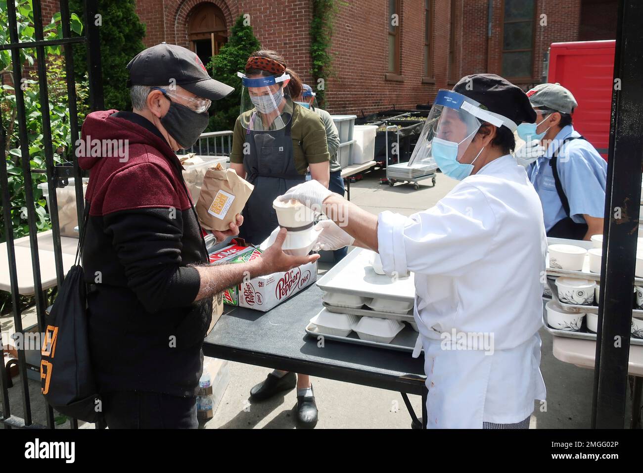 Ginger Pierce, center, and Pablo Guzman, right, hand out food at the ...
