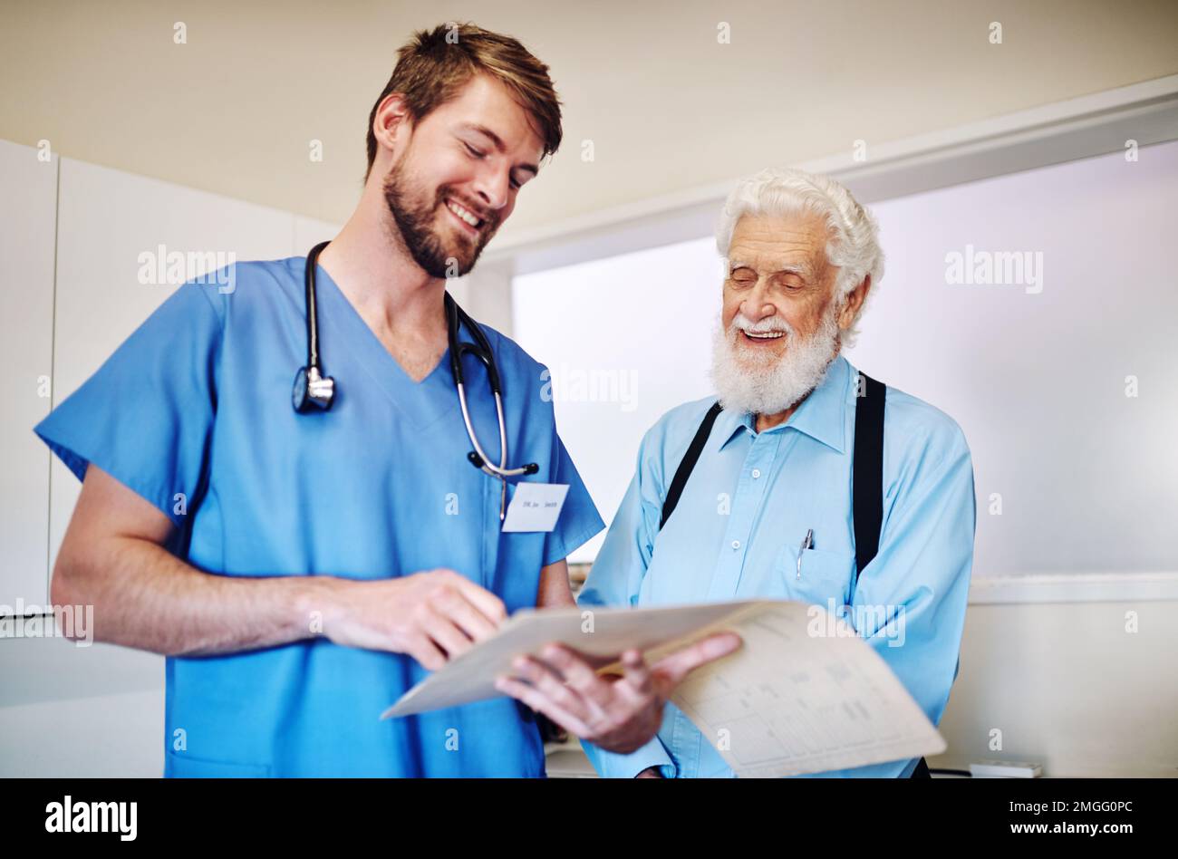 Going through some test results with a patient. a young doctor going ...