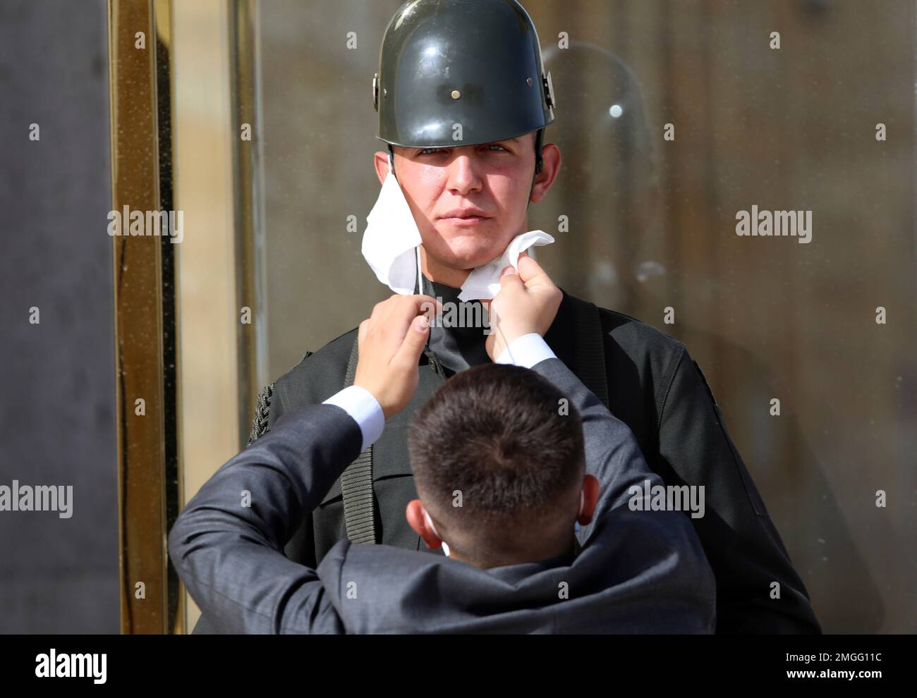 A man wipes the face of a Turkish soldier wearing a face mask for ...