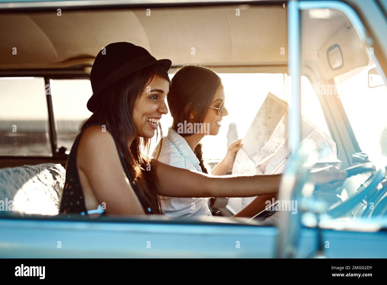 Get lost and have fun doing it. two friends reading a map on their road ...