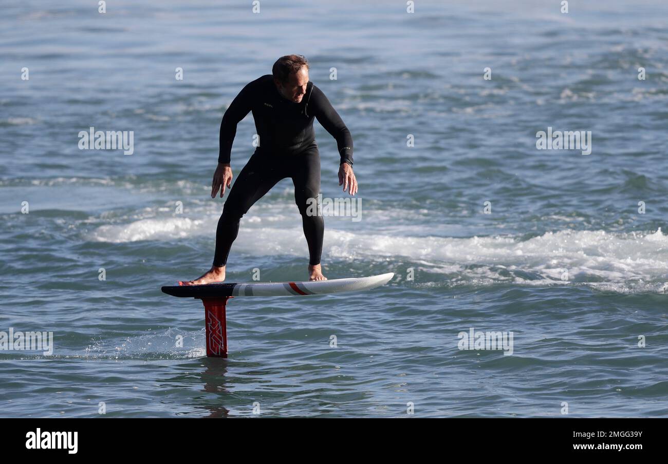 A surfer rides his hydrofoil surfboard at Sumner Beach near in ...