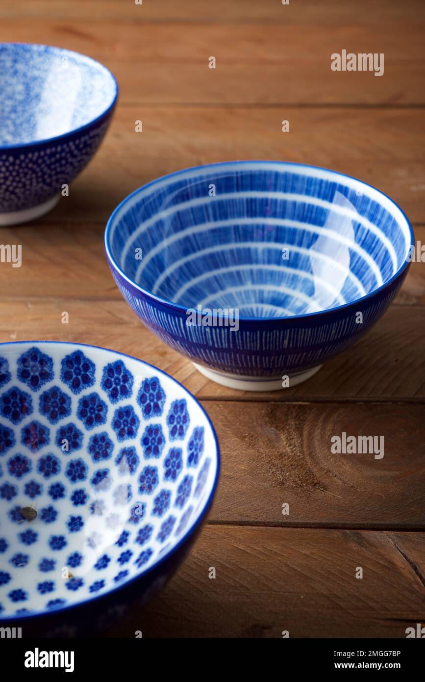 White and blue ceramic bowls on a wood table Stock Photo - Alamy