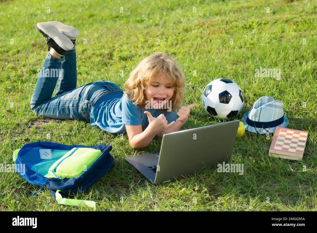 Excited child using laptop computer in park. Learning online, outdoor ...