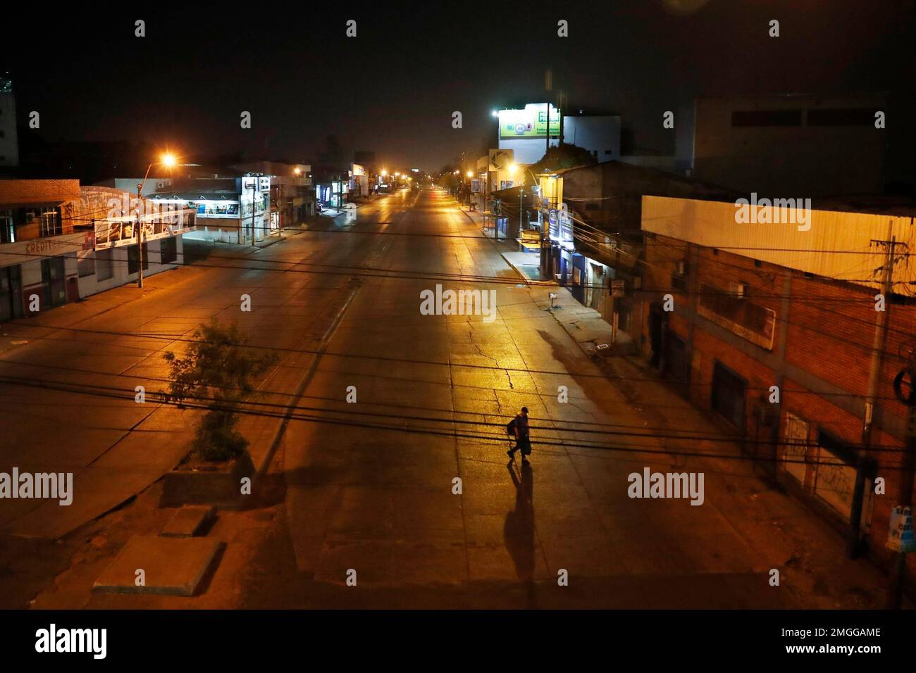 A man crosses an empty Eusebio Ayala Avenue during a curfew to curb the ...