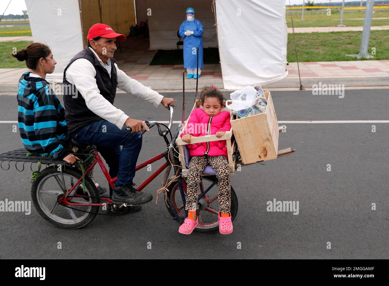 A family waits on their bicycle to be tested for COVID-19 at a mobile ...