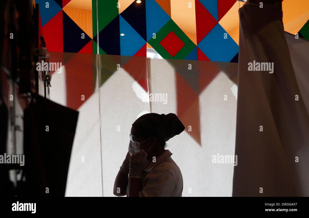 A restaurant worker puts on a face mask against the spread of the new ...