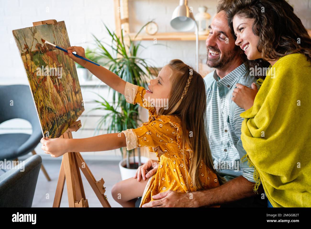 Happy family concept. Young parents with children painting together at ...