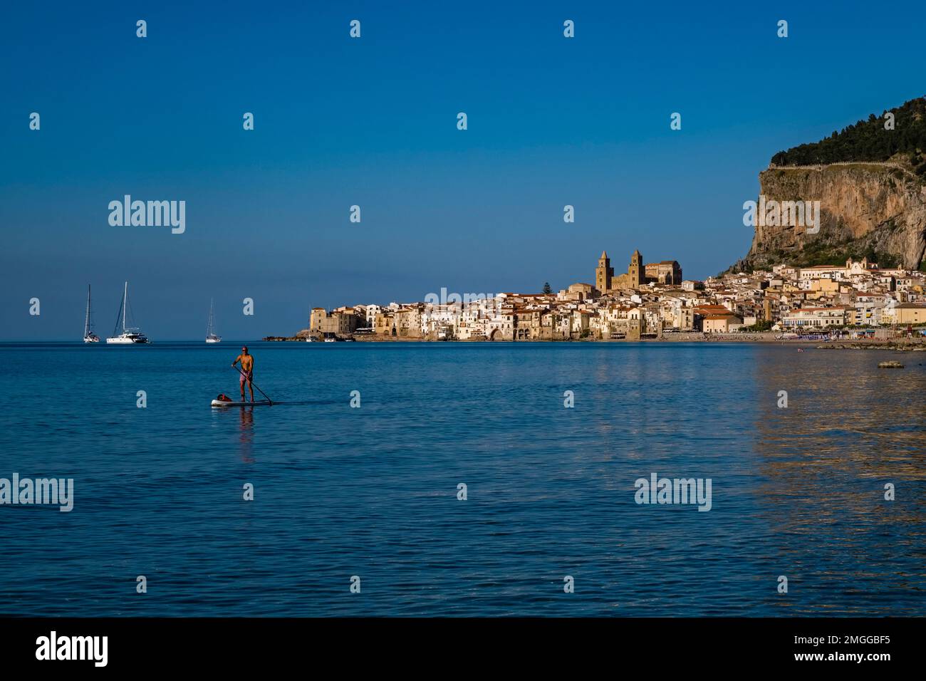 View across the sea to the medieval town of Cefalu, located on the ...