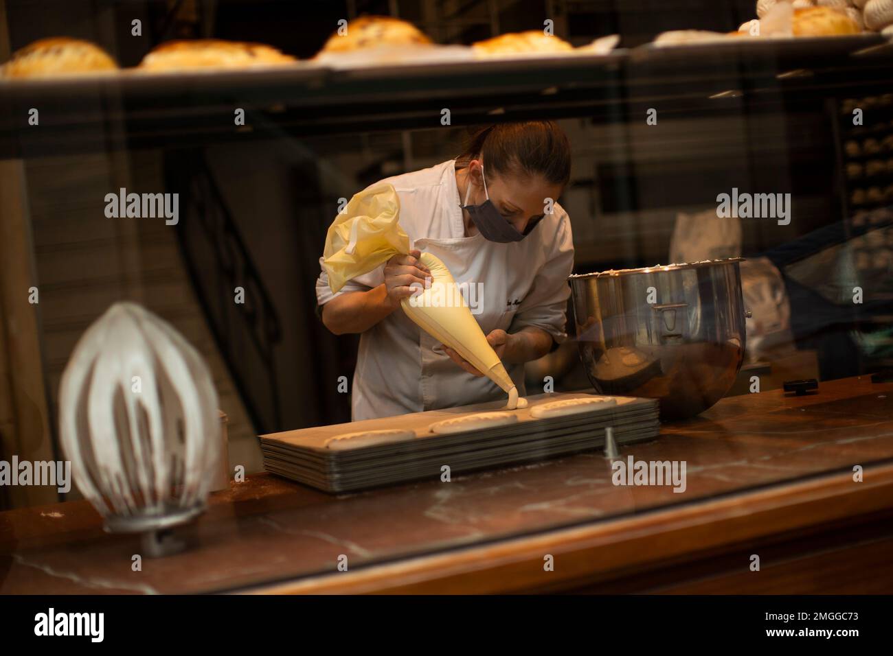A pastry cook, wearing a mouth mask to protect against coronavirus ...