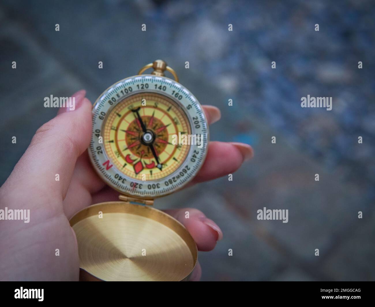 close up of golden compass in hand,streetb background Stock Photo - Alamy