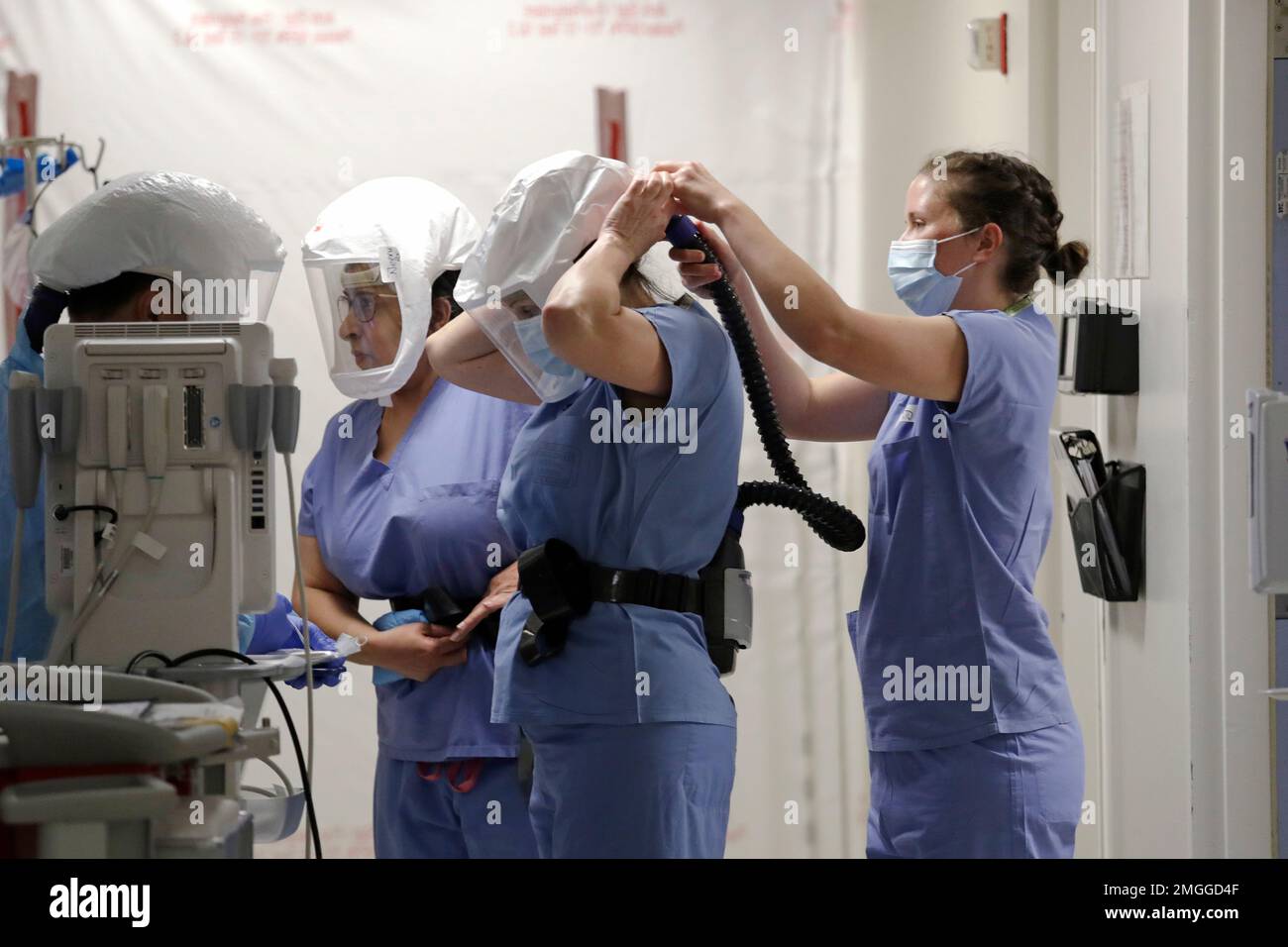 Medical staff workers put on protective equipment, including powered ...